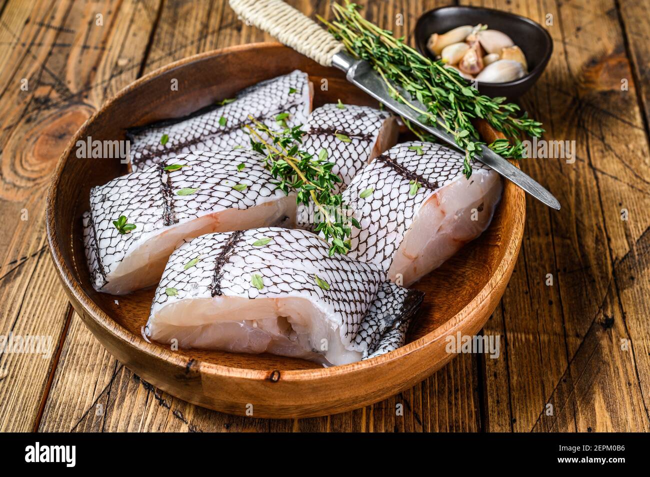 Cut Raw grenadier macrurus white fish without head in a wooden plate ...