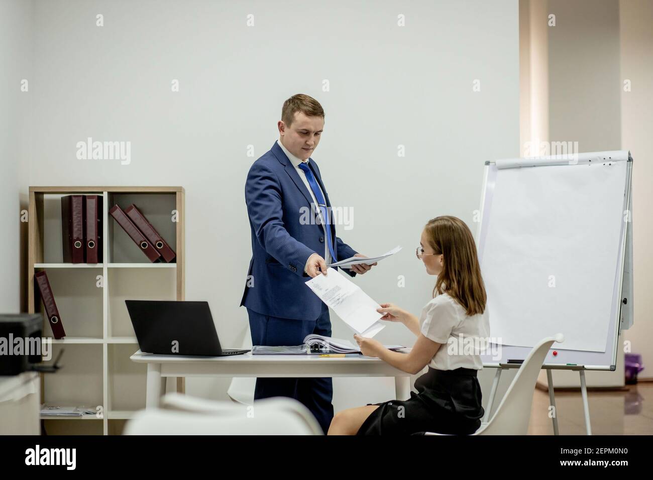 Pretty female showing document to her boss in the office Stock Photo ...