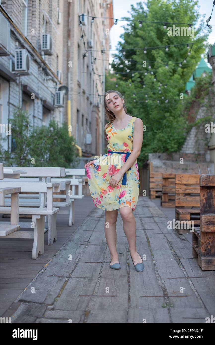 girl in dress walks through the old town in the summer. Beautiful ...
