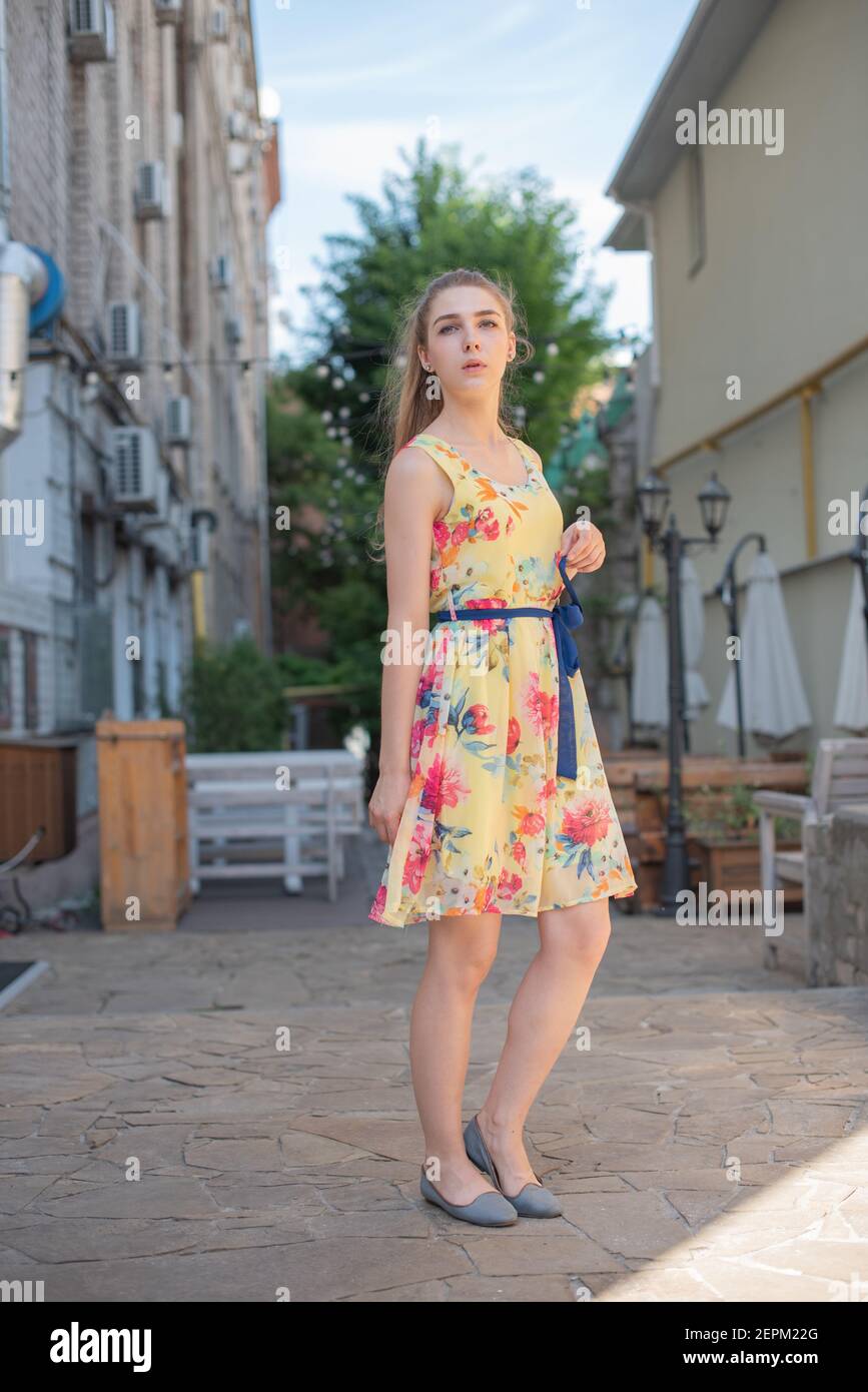 girl in dress walks through the old town in the summer. Beautiful ...