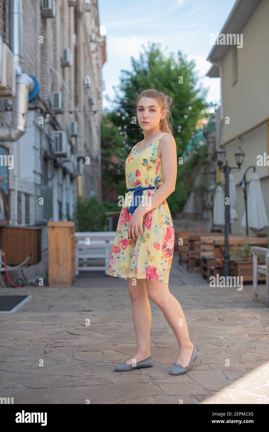 girl in dress walks through the old town in the summer. Beautiful ...