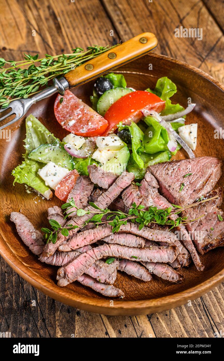 BBQ beef meat chop sirloin steak on a wooden plate with vegetable salad ...
