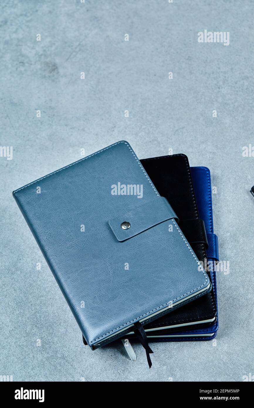 Three notebooks and a pen on a blue background. Flat lay Stock Photo ...