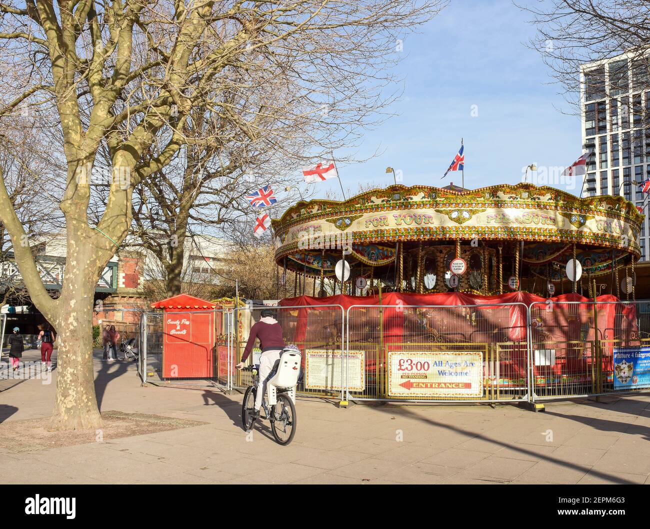 London, UK. 06th Jan, 2014. Man rides past the closed fun fair ride in ...