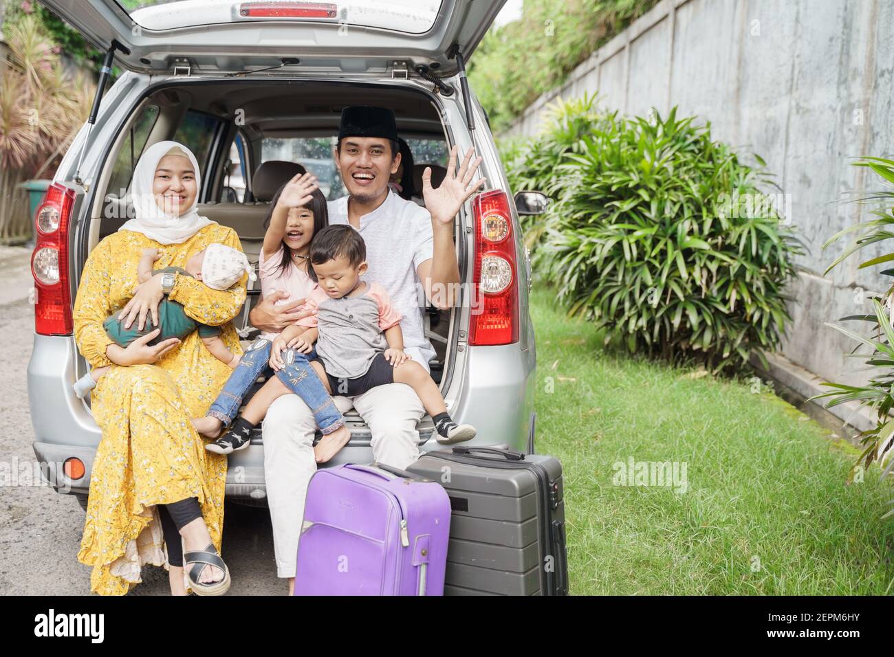 Muslim family ready to holiday while sitting on the trunk of their car ...