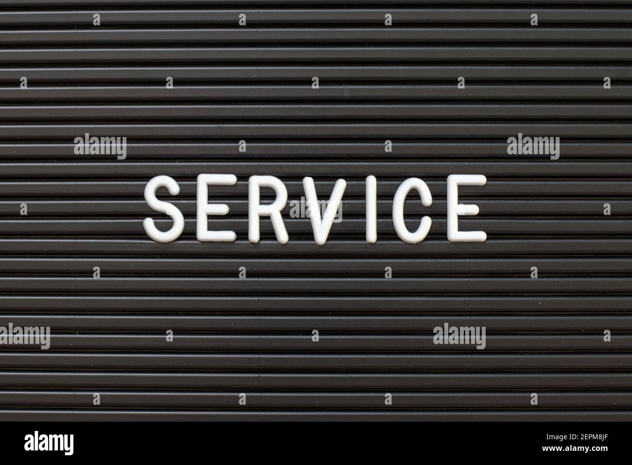 White alphabet in word service on black color felt letter board ...