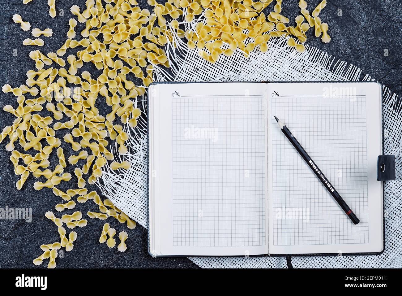Raw pasta with notebook and pencil on marble background Stock Photo - Alamy