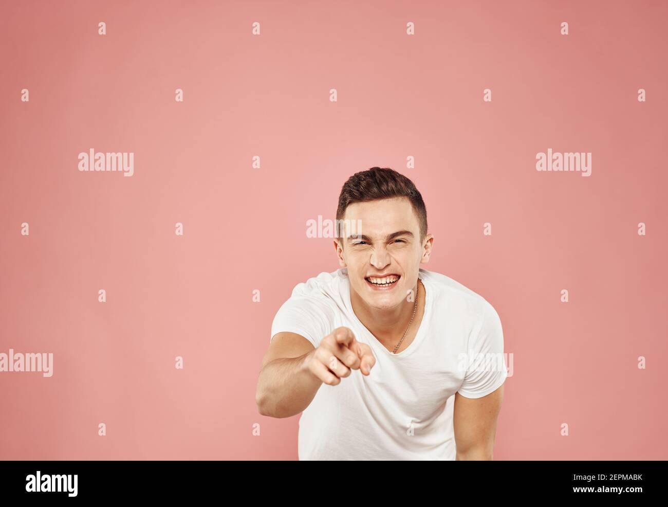 A man gestures with his hands in a white t-shirt emotions pink ...