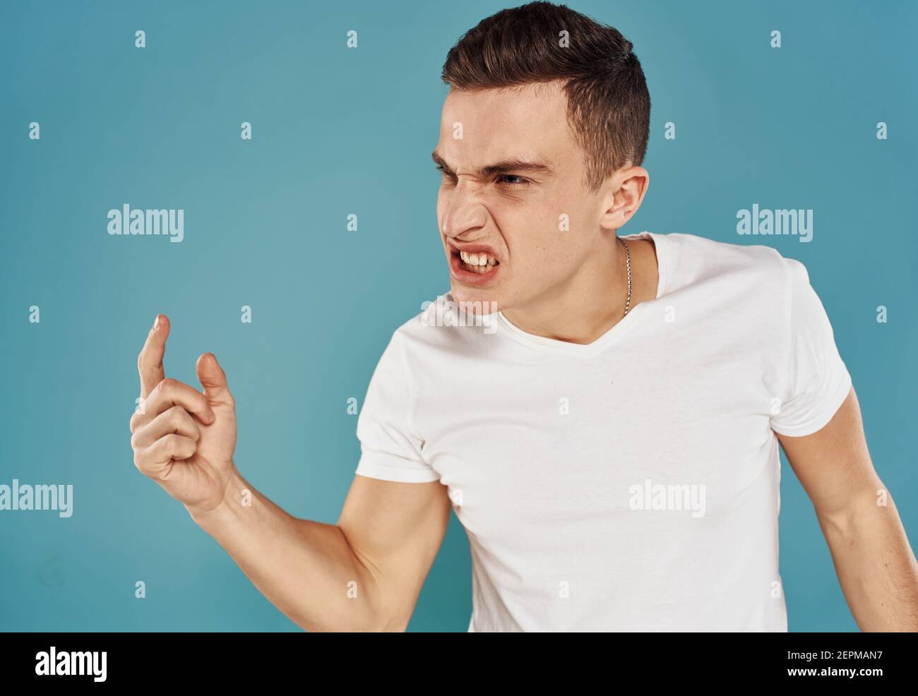 The guy on a blue background gestures with his hands aggression model ...