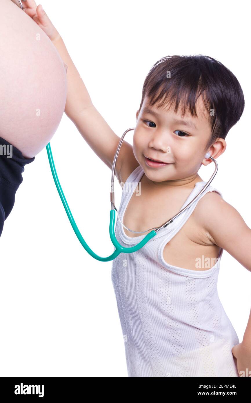 Little asian boy in a white singlet examining pregnant mother's tummy ...