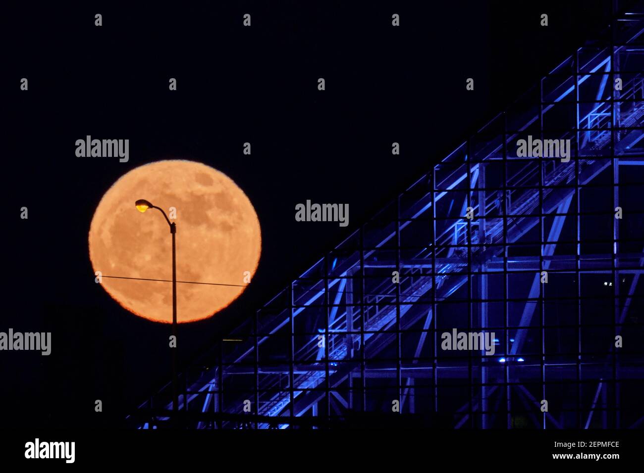 The Wolf Moon rises behind the Convention Center in Portland, Ore., on ...