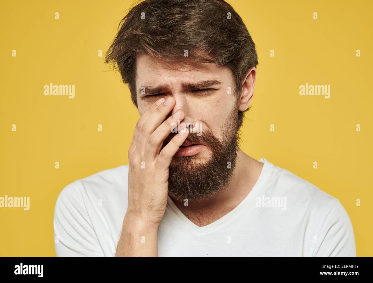 Upset guy crying on a yellow background and gesturing with his hands ...