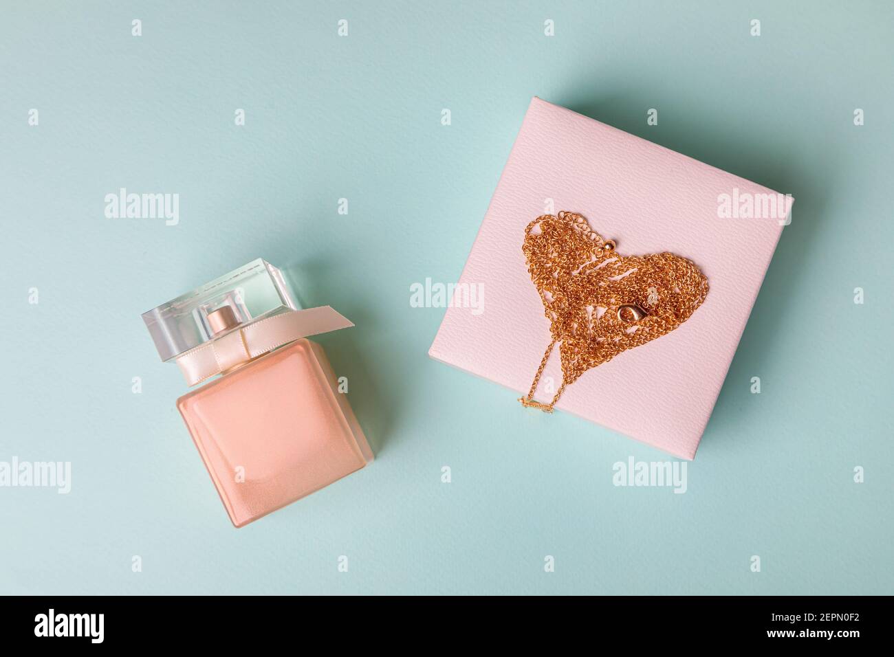 A gift for Valentine's Day. Perfume and a box with a gold chain on a ...