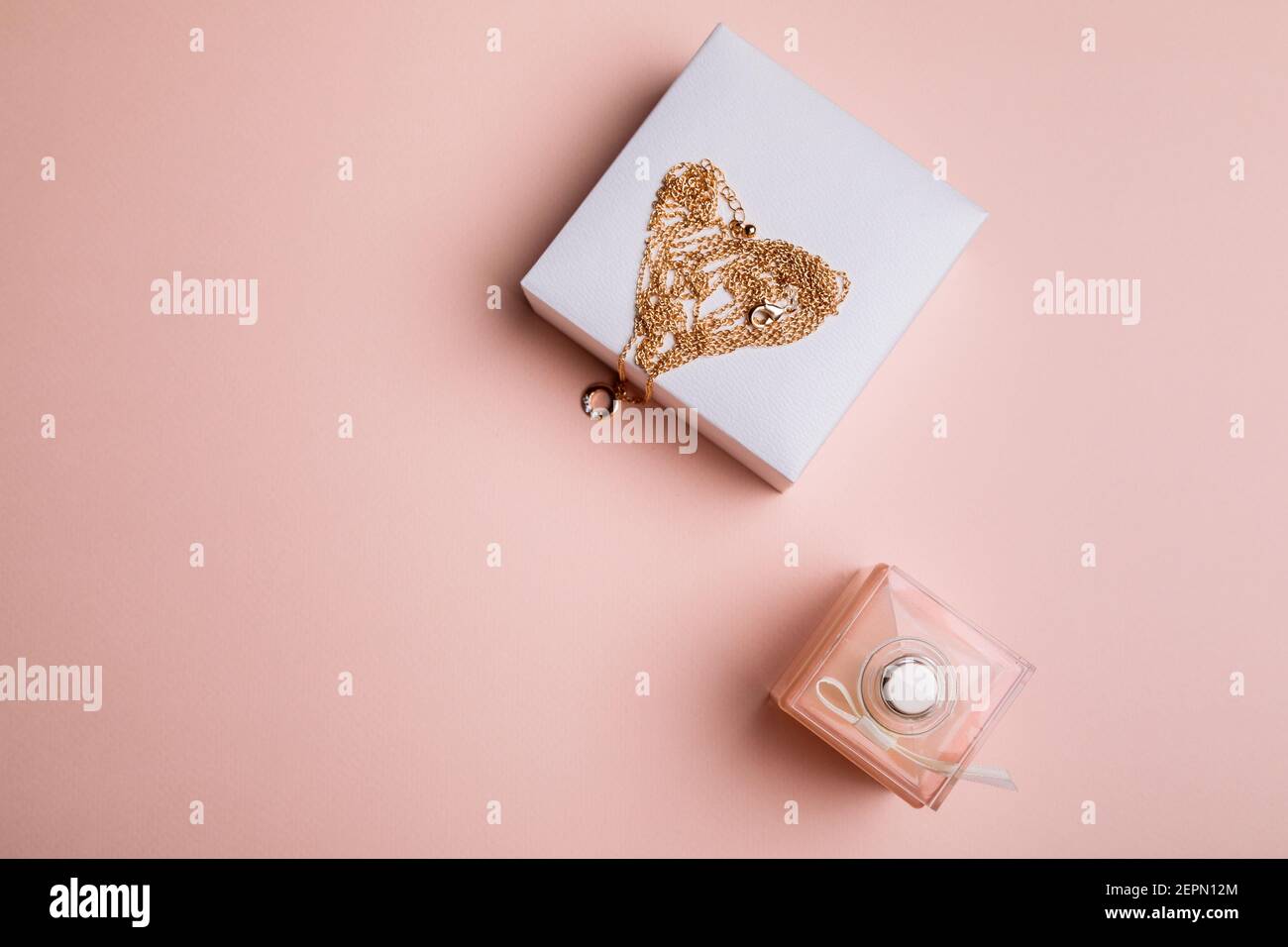 A gift for Valentine's Day. Perfume and a box with a gold chain on a ...