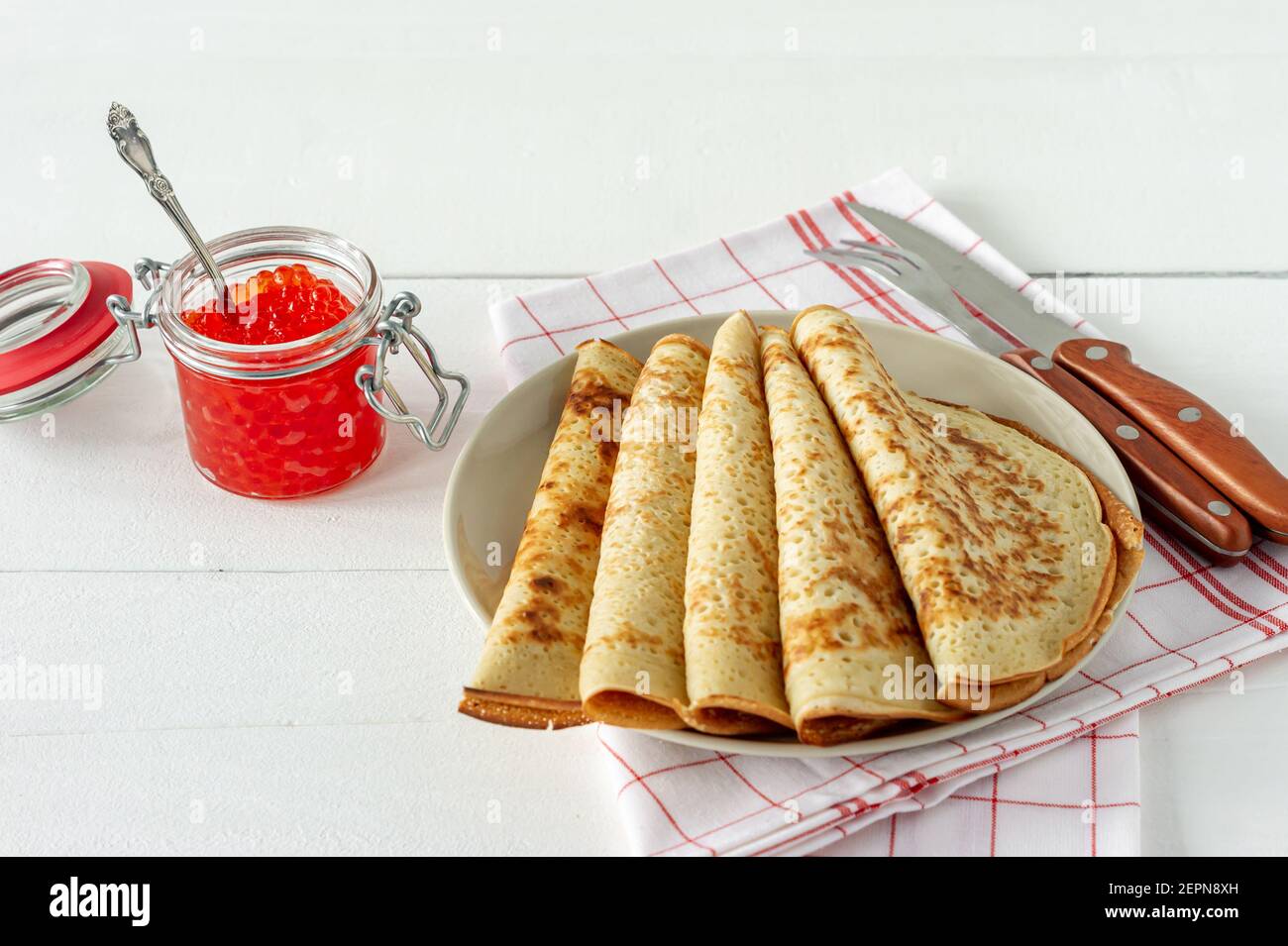 Traditional Russian Crepes Blini on a plate with red caviar on light ...