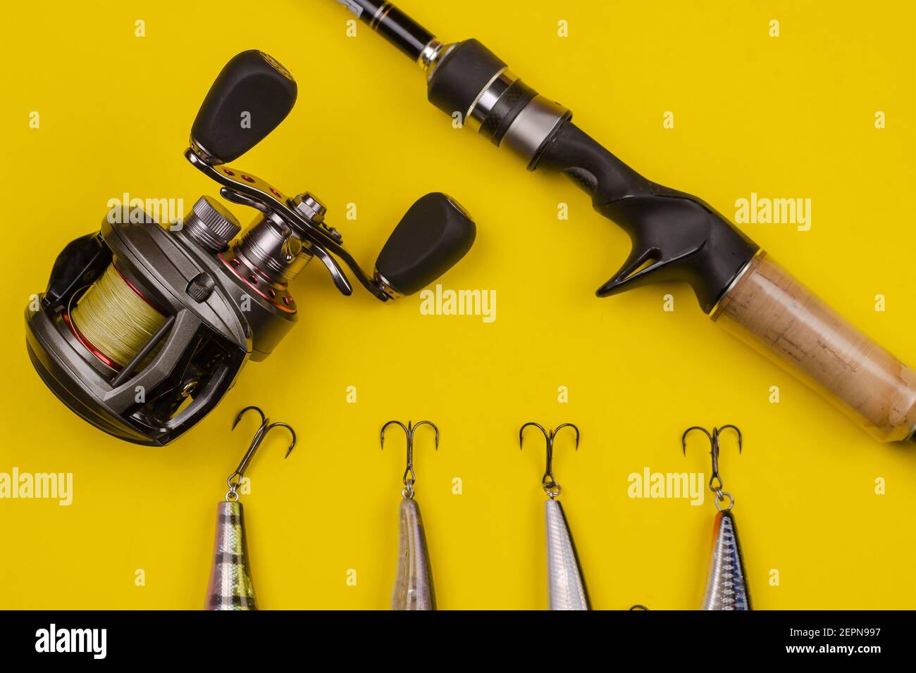 Fishing rod baitcasting reel and baits on a yellow background. Fishing ...