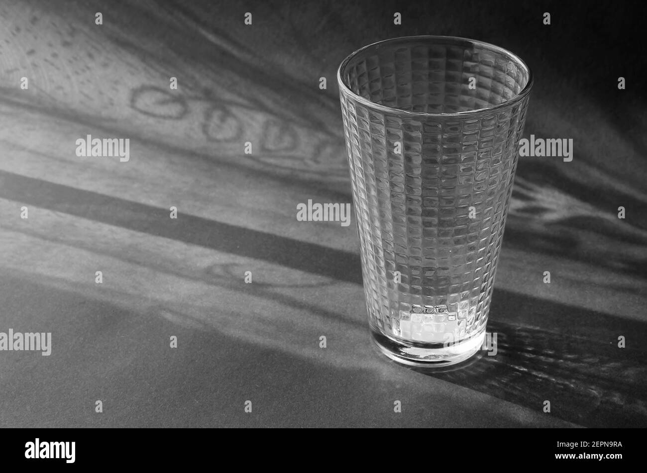 Empty glass beaker on a gray surface with shadows. Transparent glass ...