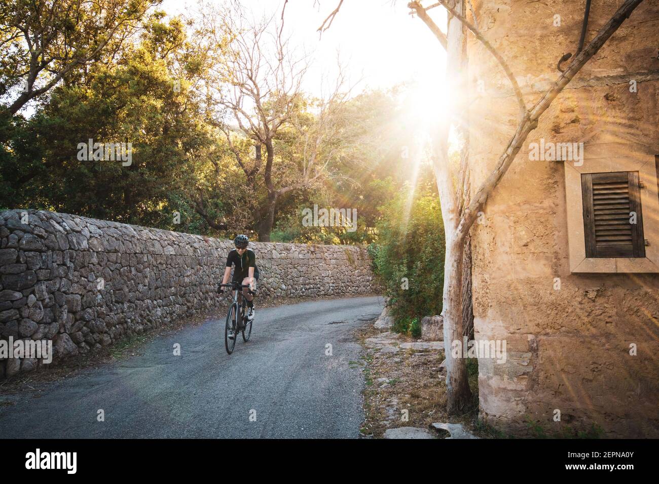 Anonymous female cyclist in casual outfit riding bicycle alone in empty ...