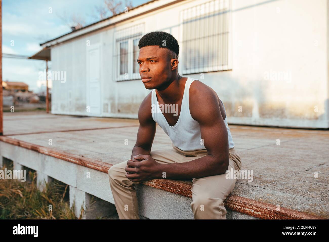 Distant anonymous female in elegant wear standing near modern red ...