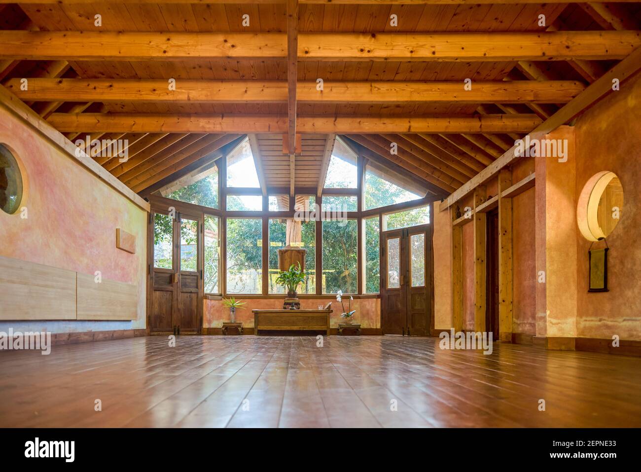 Interior of spacious meditation hall in house with potted plants and ...