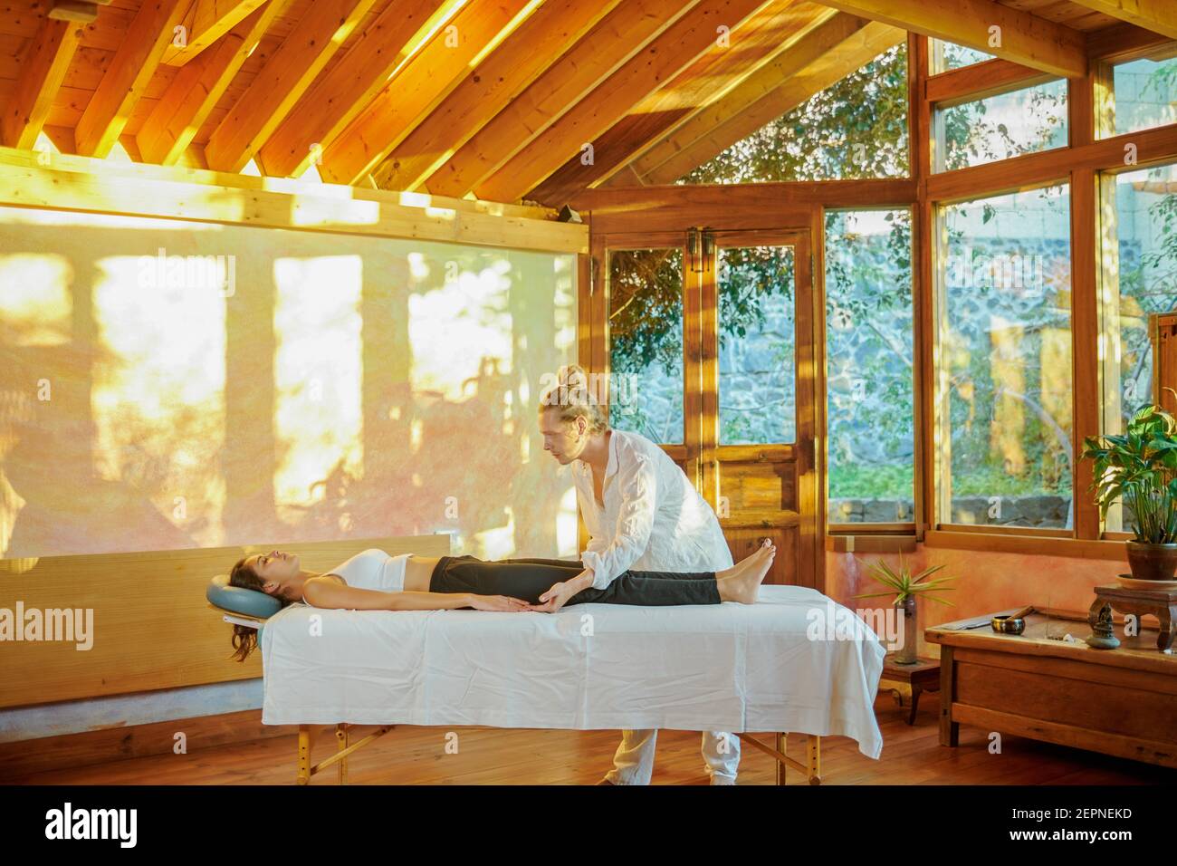 Healer practicing palm healing technique for female client lying on ...