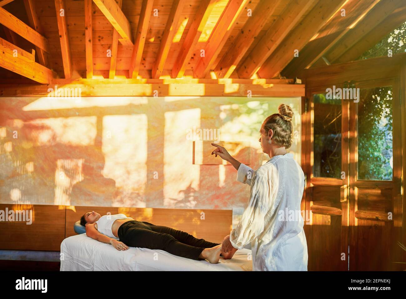 Healer practicing palm healing technique for female client lying on ...