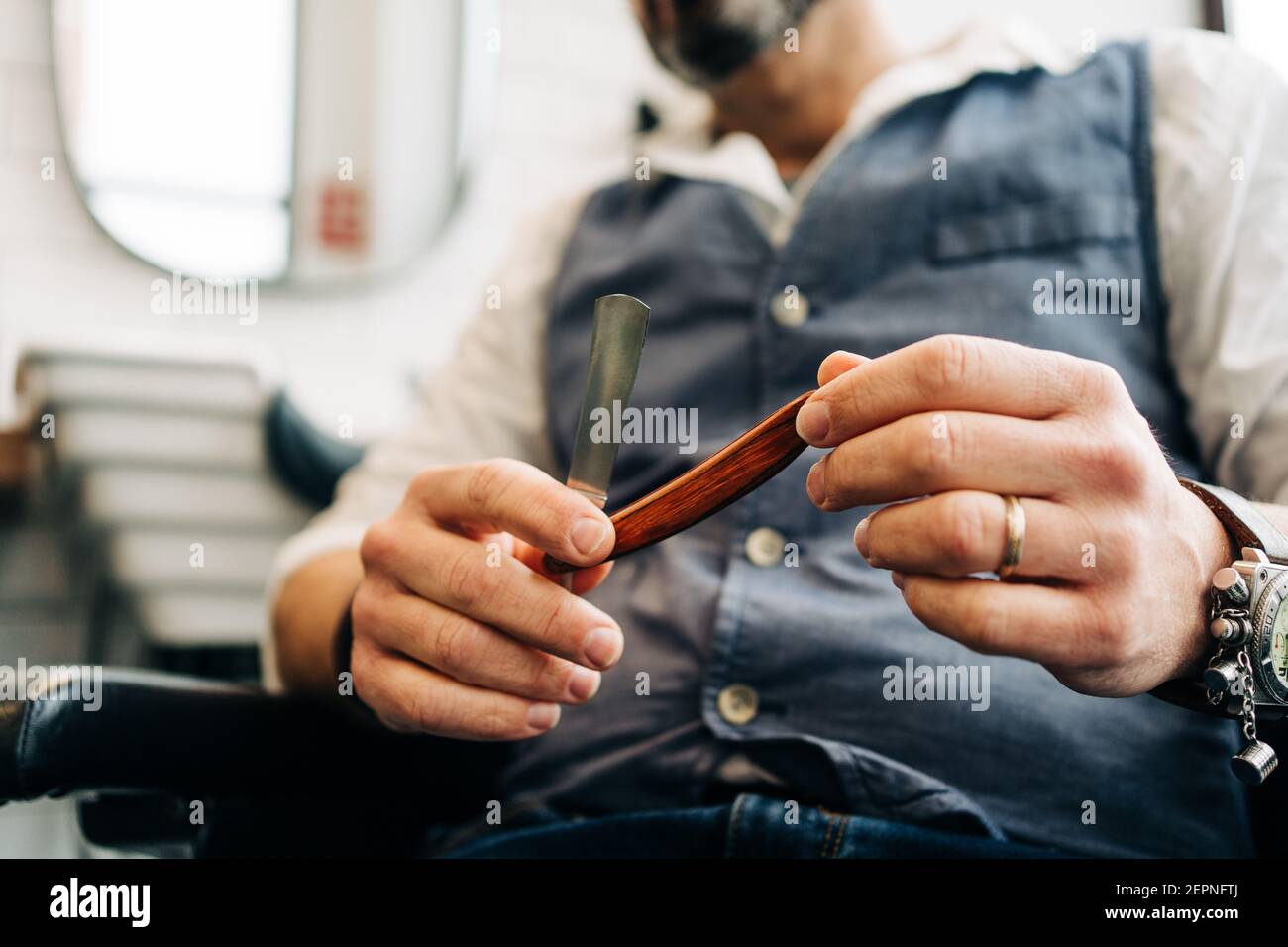 Crop unrecognizable male stylist holding straight razor with sharp ...