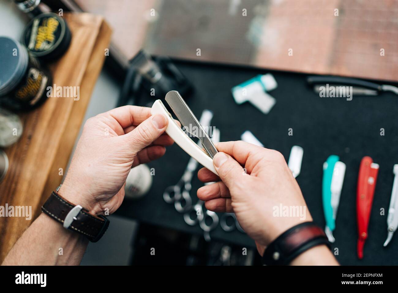 Crop anonymous beauty master with collection of razors and manual ...