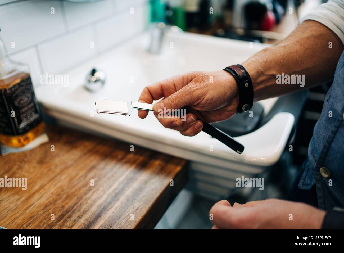 Crop unrecognizable male stylist holding straight razor with sharp ...