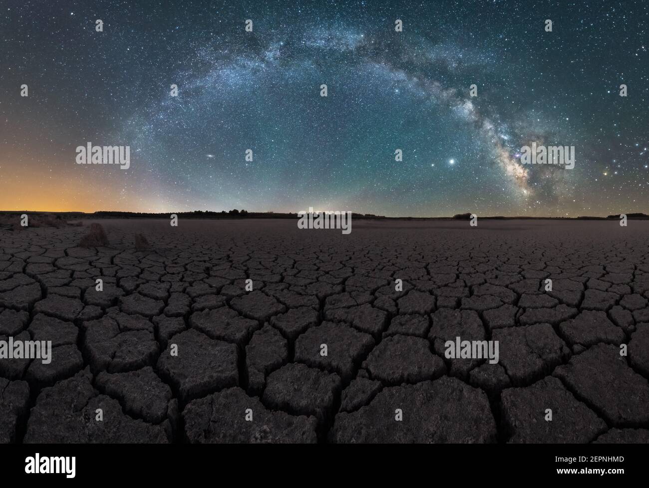 Drought cracked lifeless ground arid terrain with starry sky at night ...