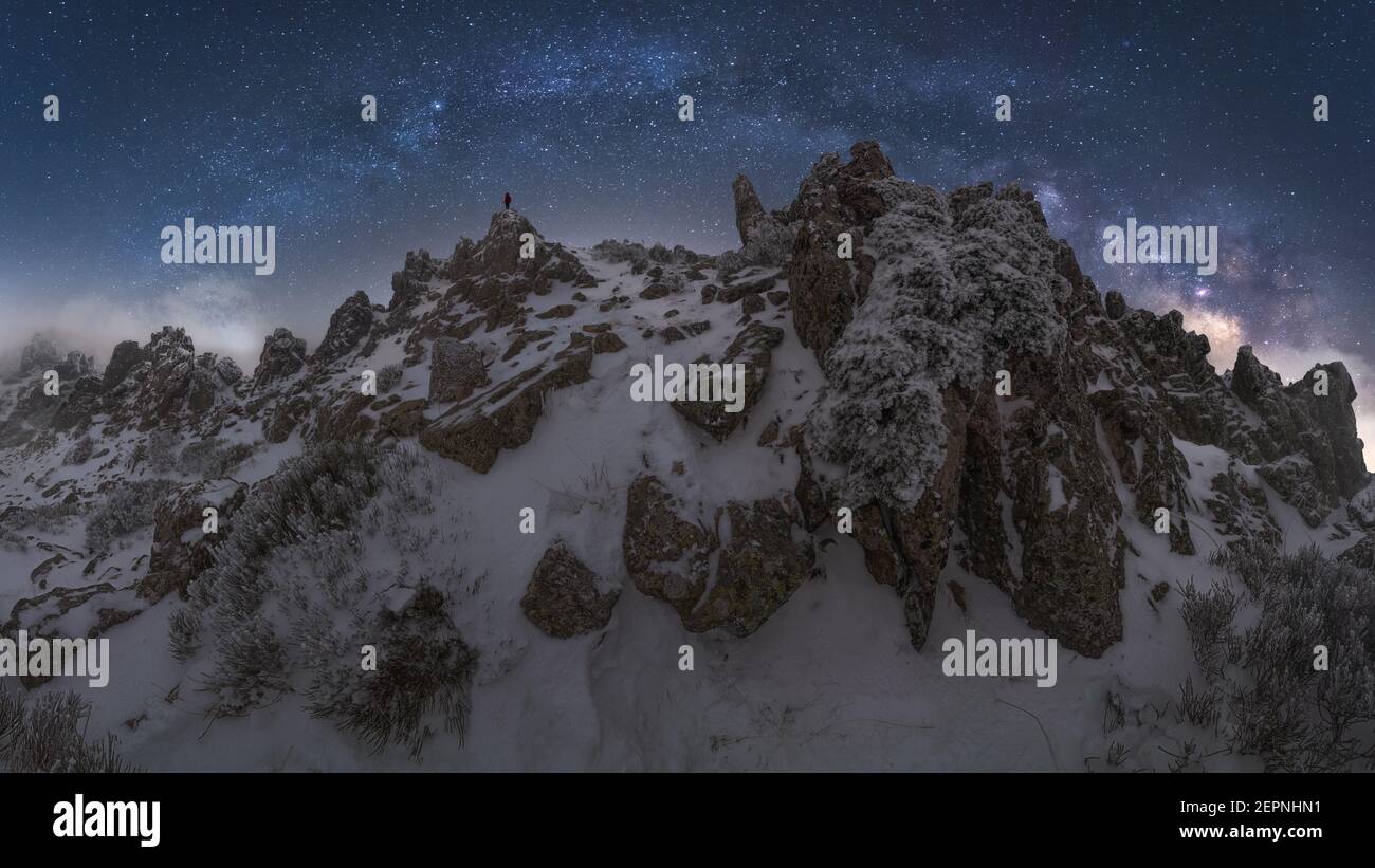 Traveler standing on cliff of snowy mountain range in Picos de Europa ...