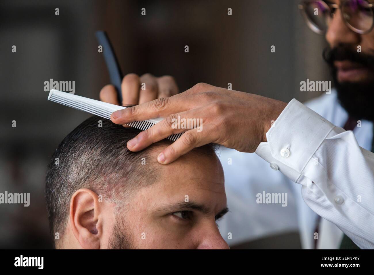 Crop stylish ethnic male beauty master removing hair of masculine ...