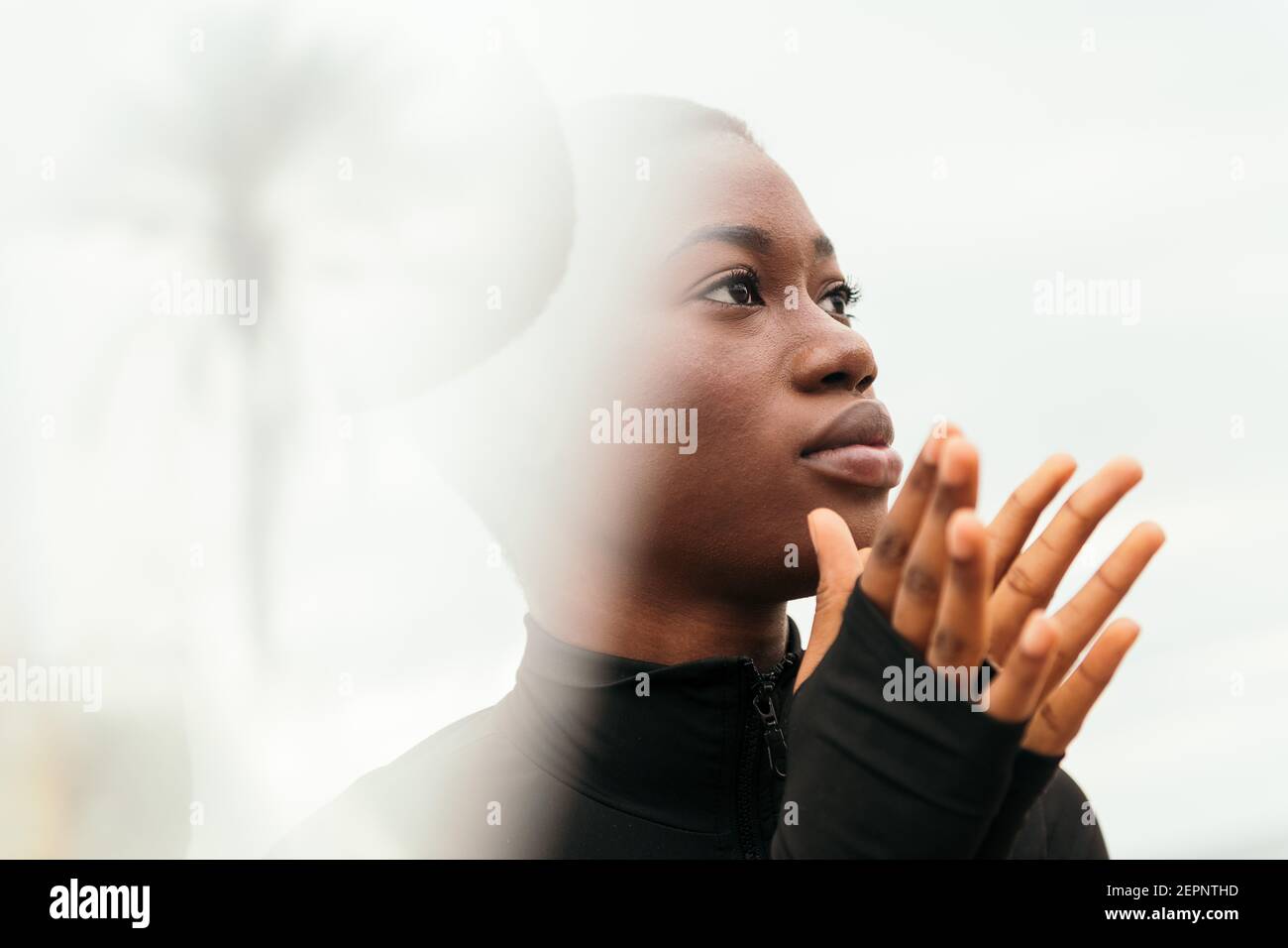 Young contemplative ethnic female with short hair touching face in ...