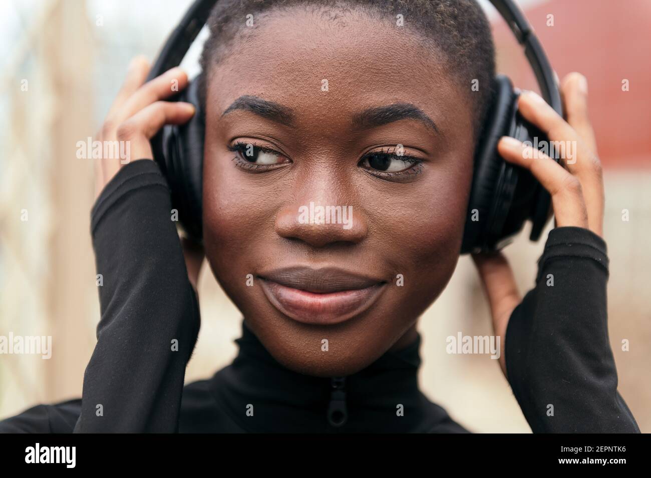 Crop Young Dreamy Black Female Listening To Music From Wireless