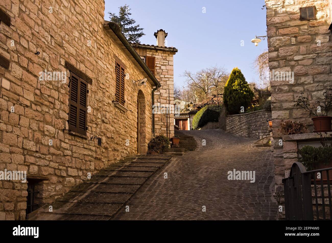 A staircase in a medieval Italian village with brick houses and floral ...