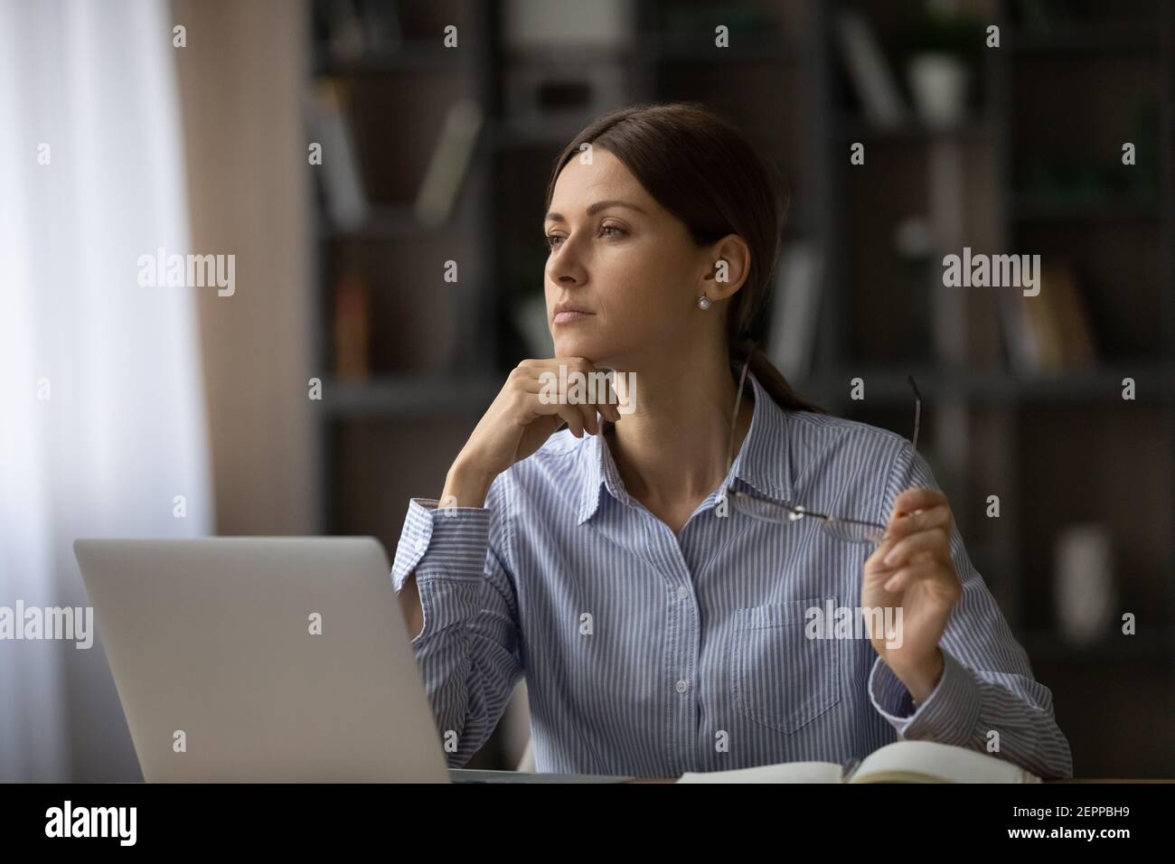 Pensive female employee look in distance thinking Stock Photo - Alamy