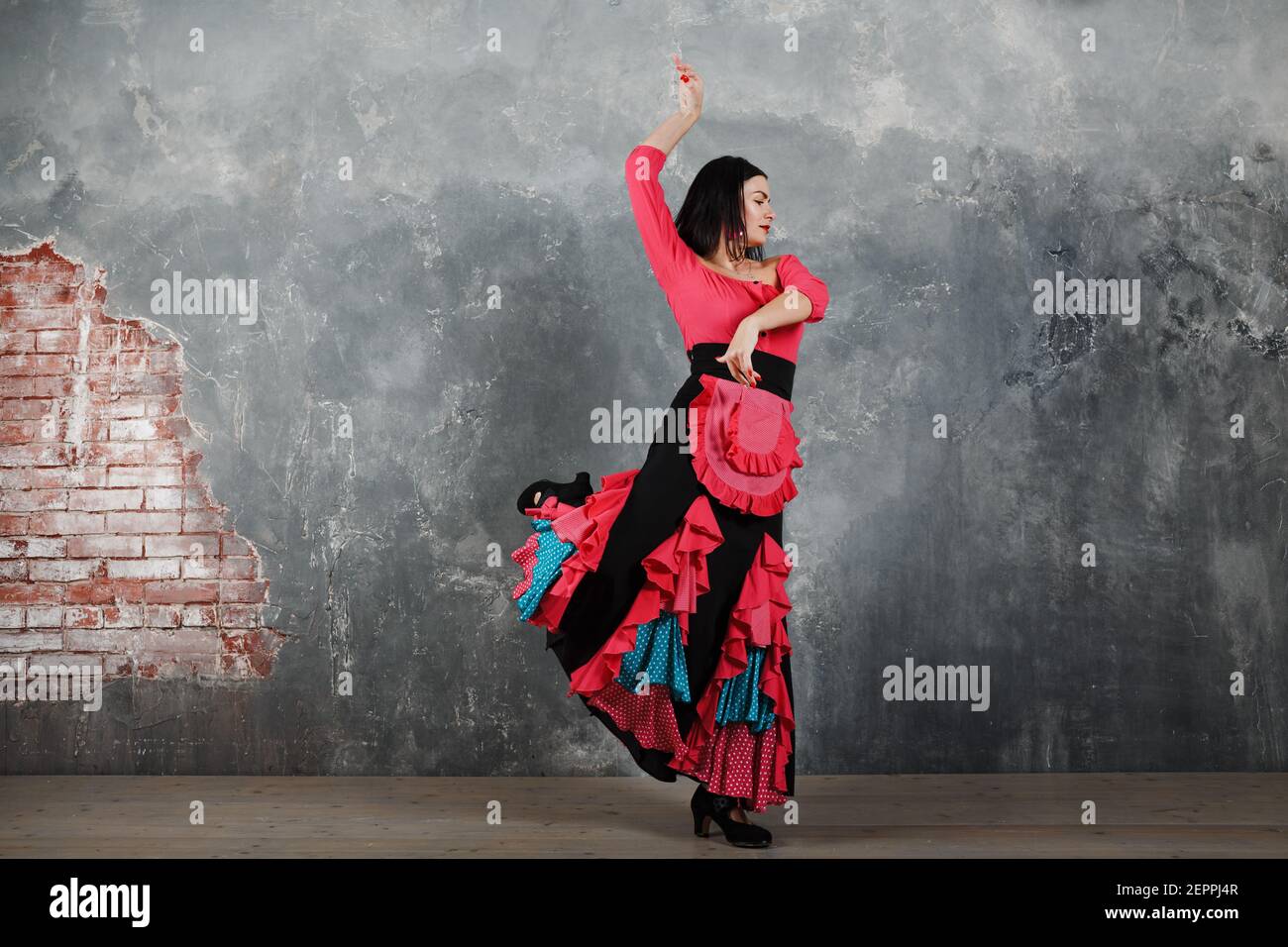 Young adult spanish woman dancing flamenco on gray vintage studio ...