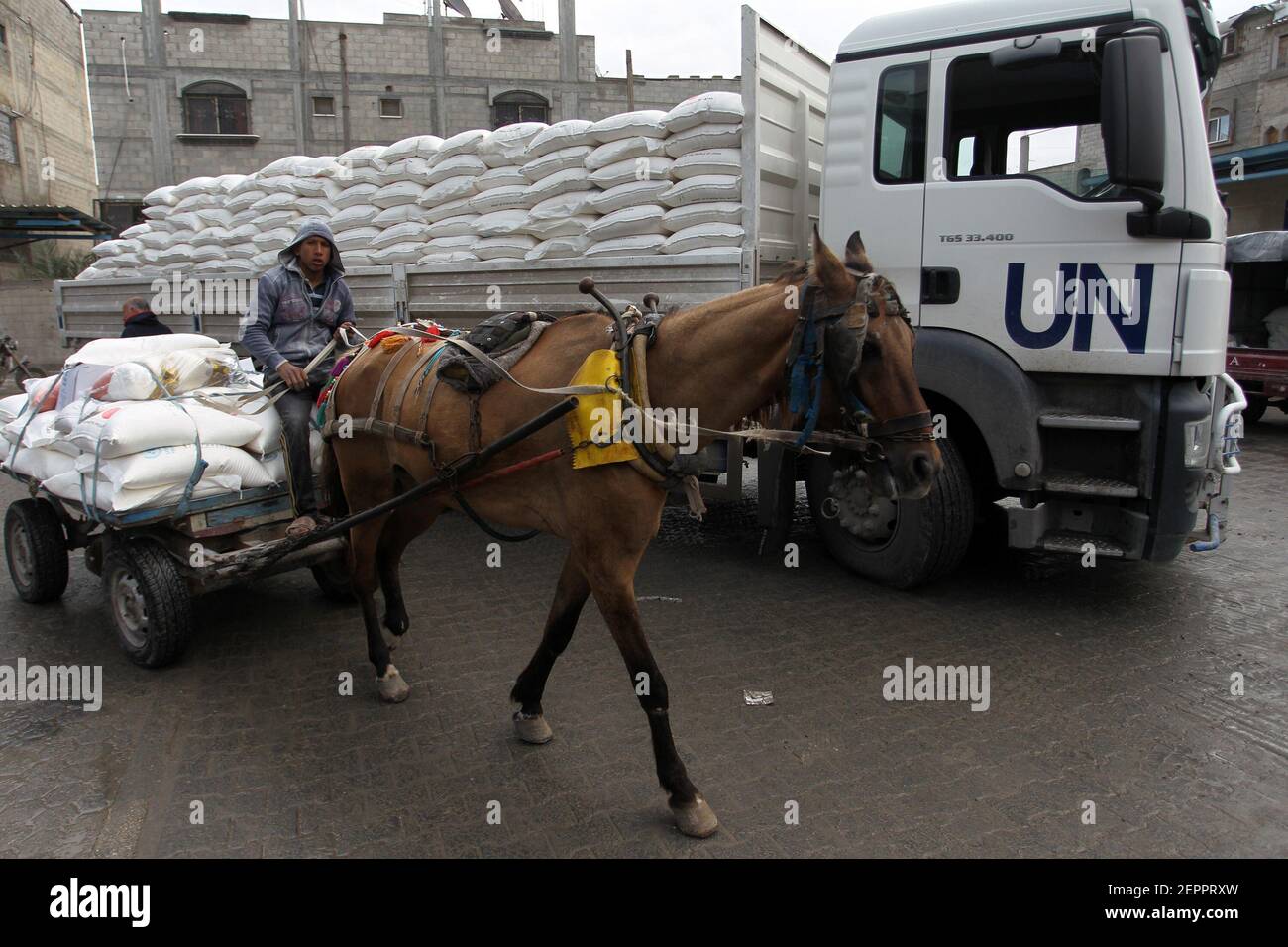 Palestinian refugees collect aid parcels at a United Nations food ...