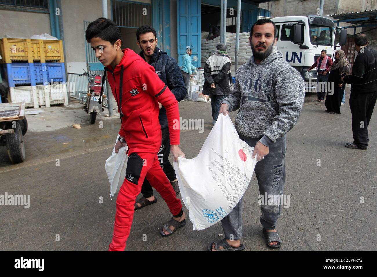 Palestinian refugees collect aid parcels at a United Nations food ...