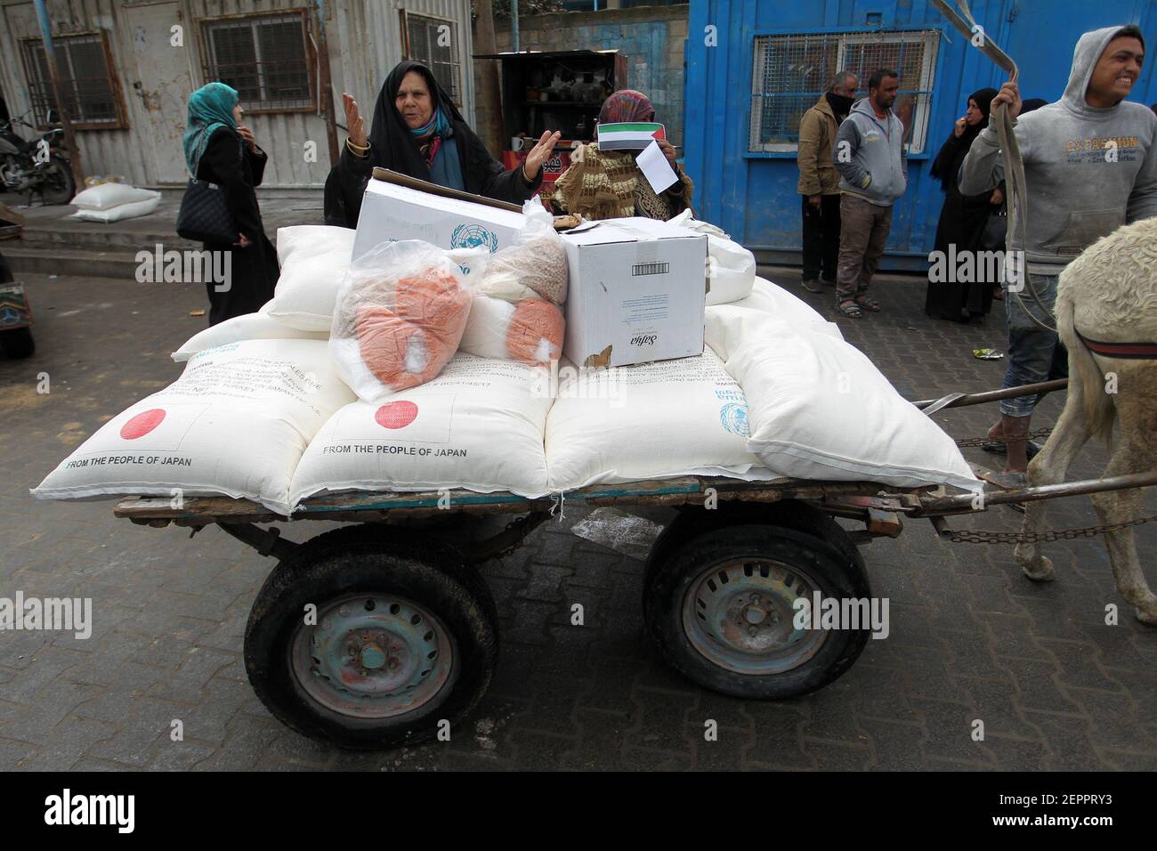 Palestinian refugees collect aid parcels at a United Nations food ...