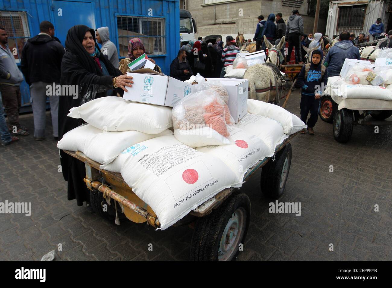 Palestinian refugees collect aid parcels at a United Nations food ...