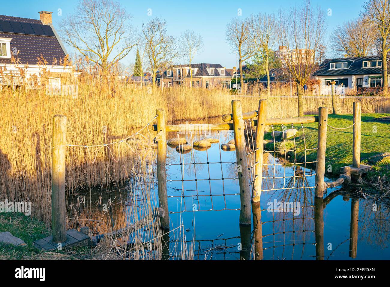Climbing fence over a small stream in a water playground Stock Photo ...