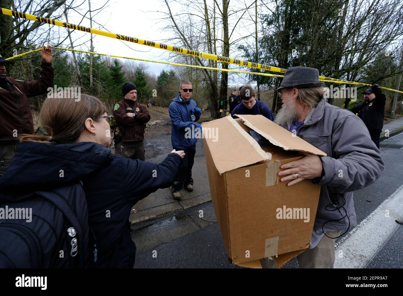 Clean up crews give a box of belongings to Steve Kimes as the "Village ...