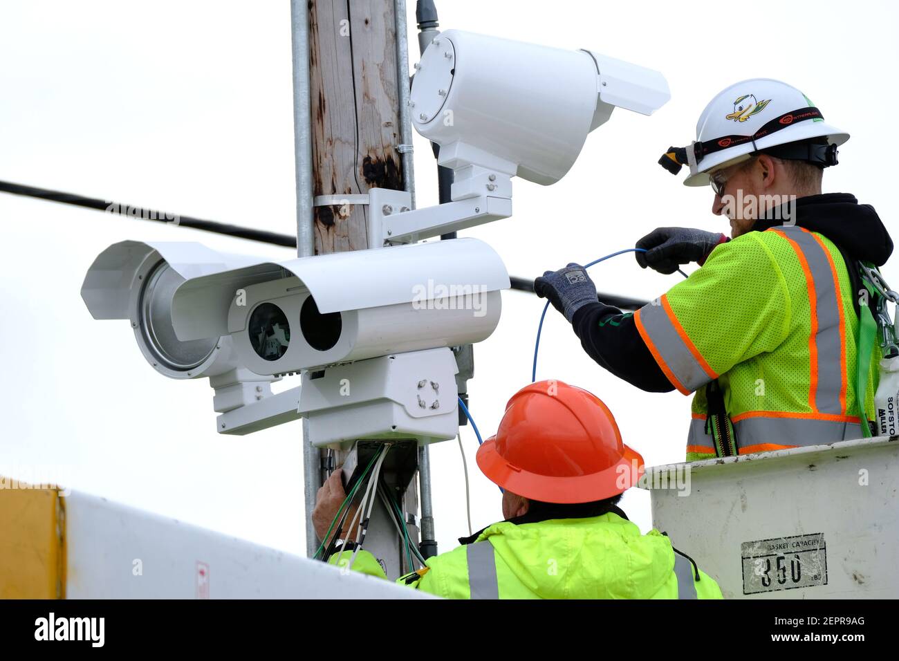 Workers install a fixed speed safety camera on Northeast Marine Drive ...