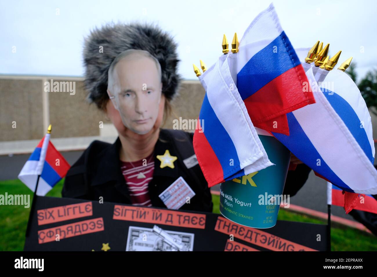 A woman dressed as Russian President Vladimir Putin hands out flags ...