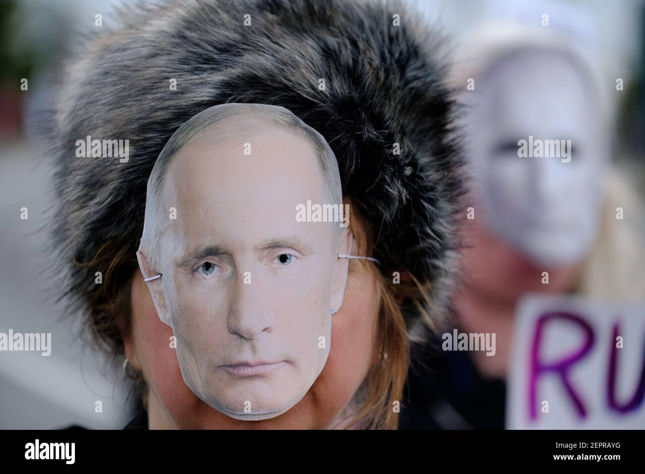 A woman wears a Vladimir Putin mask during a demonstration against ...