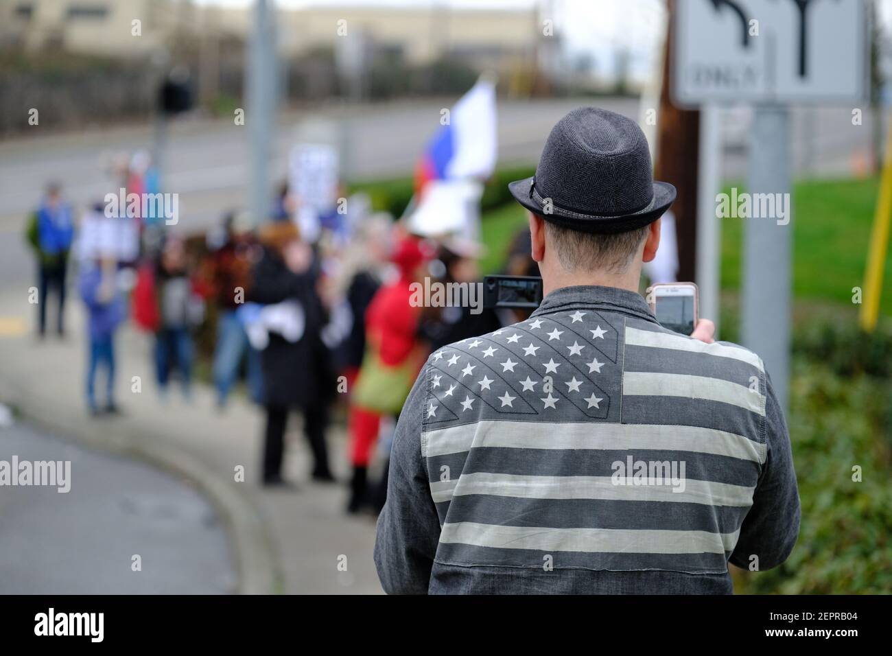 A man films the scene as protesters gather to demonstrate against ...