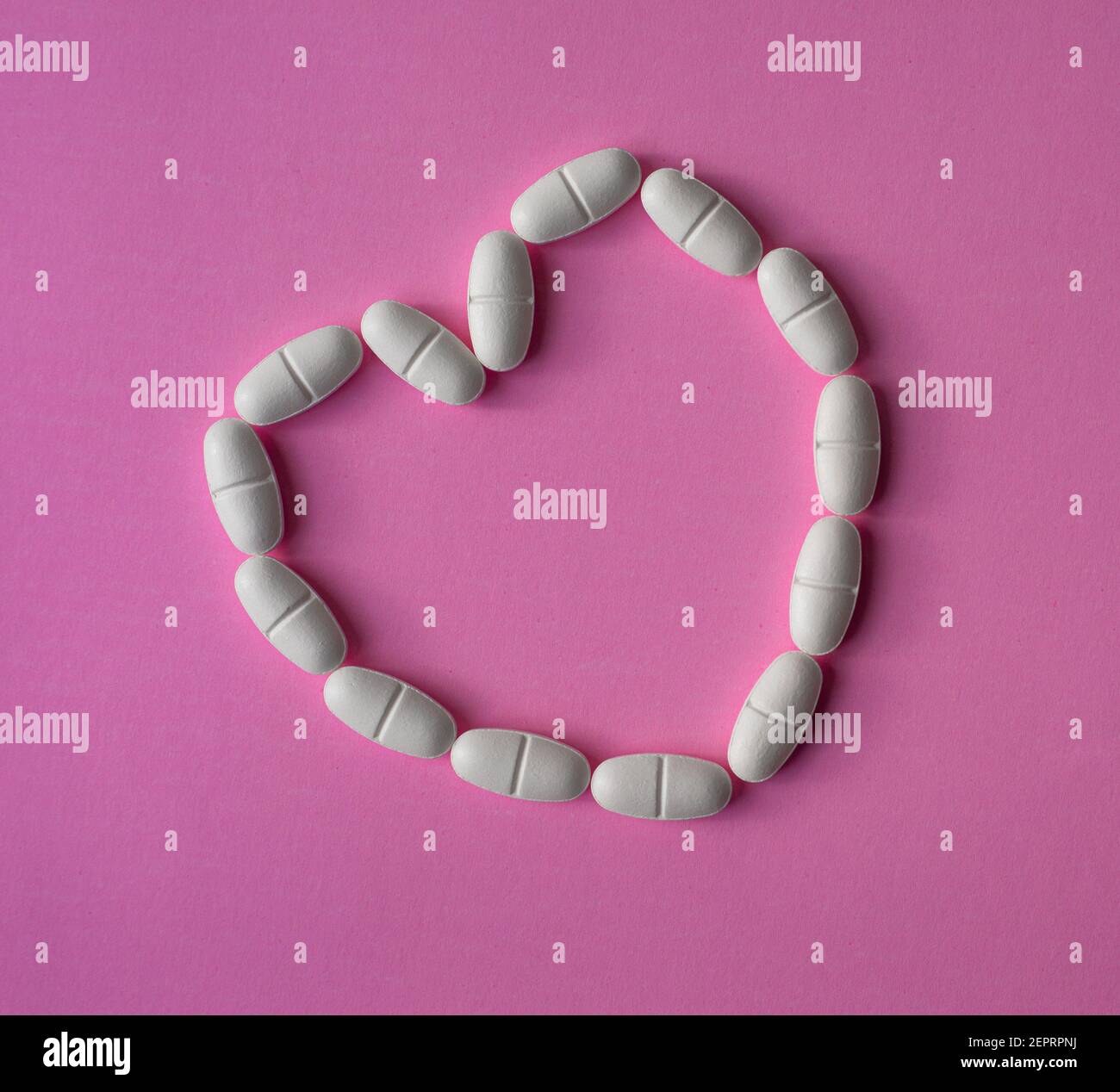 White, large pills or tablets, arranged in a heart shape to represent ...
