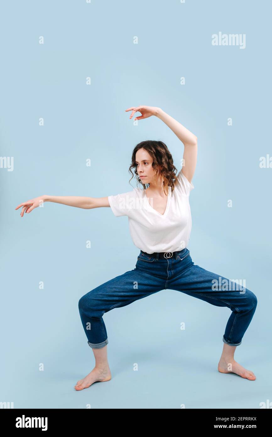 Serious contemporary dancer poses in front of blue studio background ...