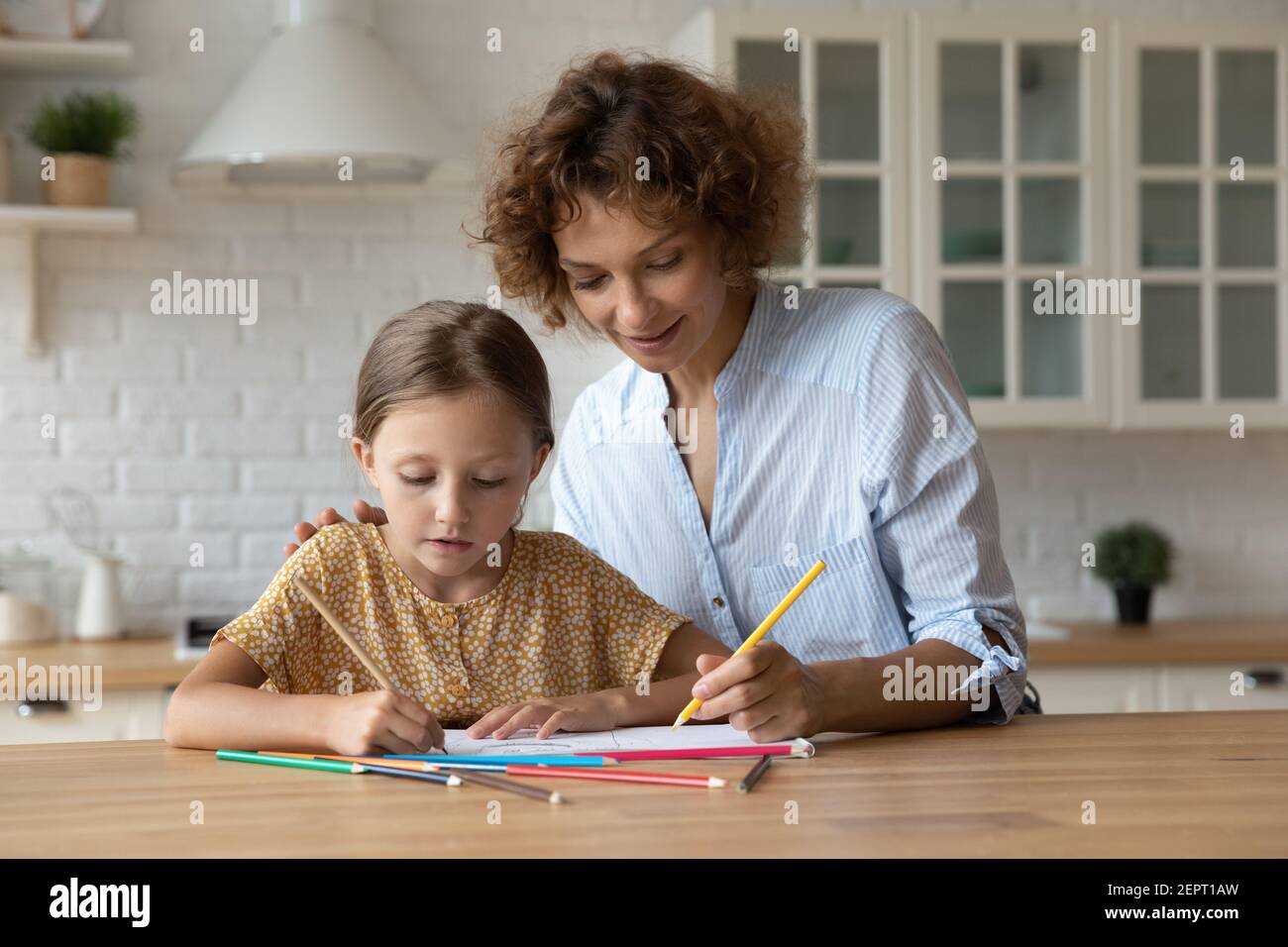 Caring millennial nanny help child to draw picture in album Stock Photo ... Caring millennial nanny help child to draw picture in album Stock Photo ...